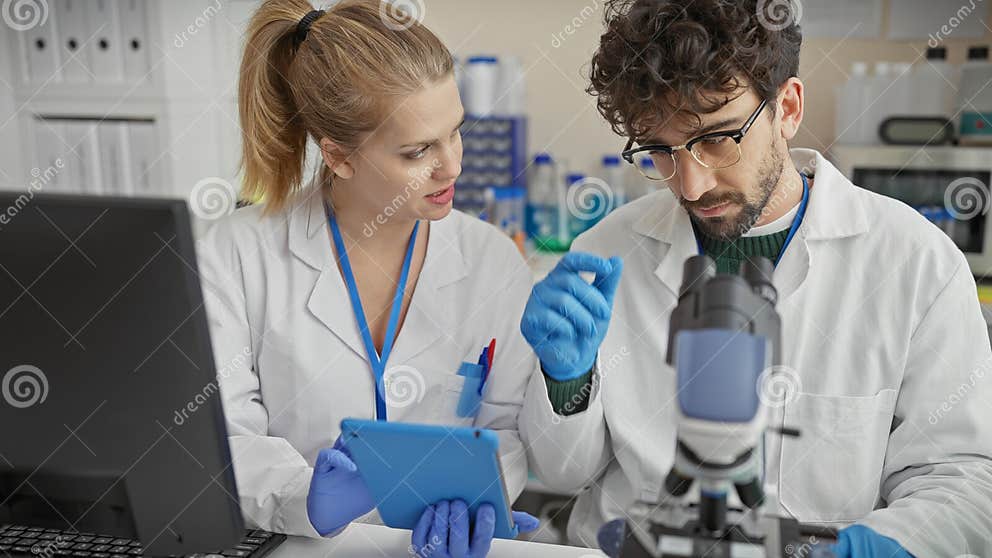 A Woman and Man Scientists Collaborating in a Laboratory, Analyzing ...