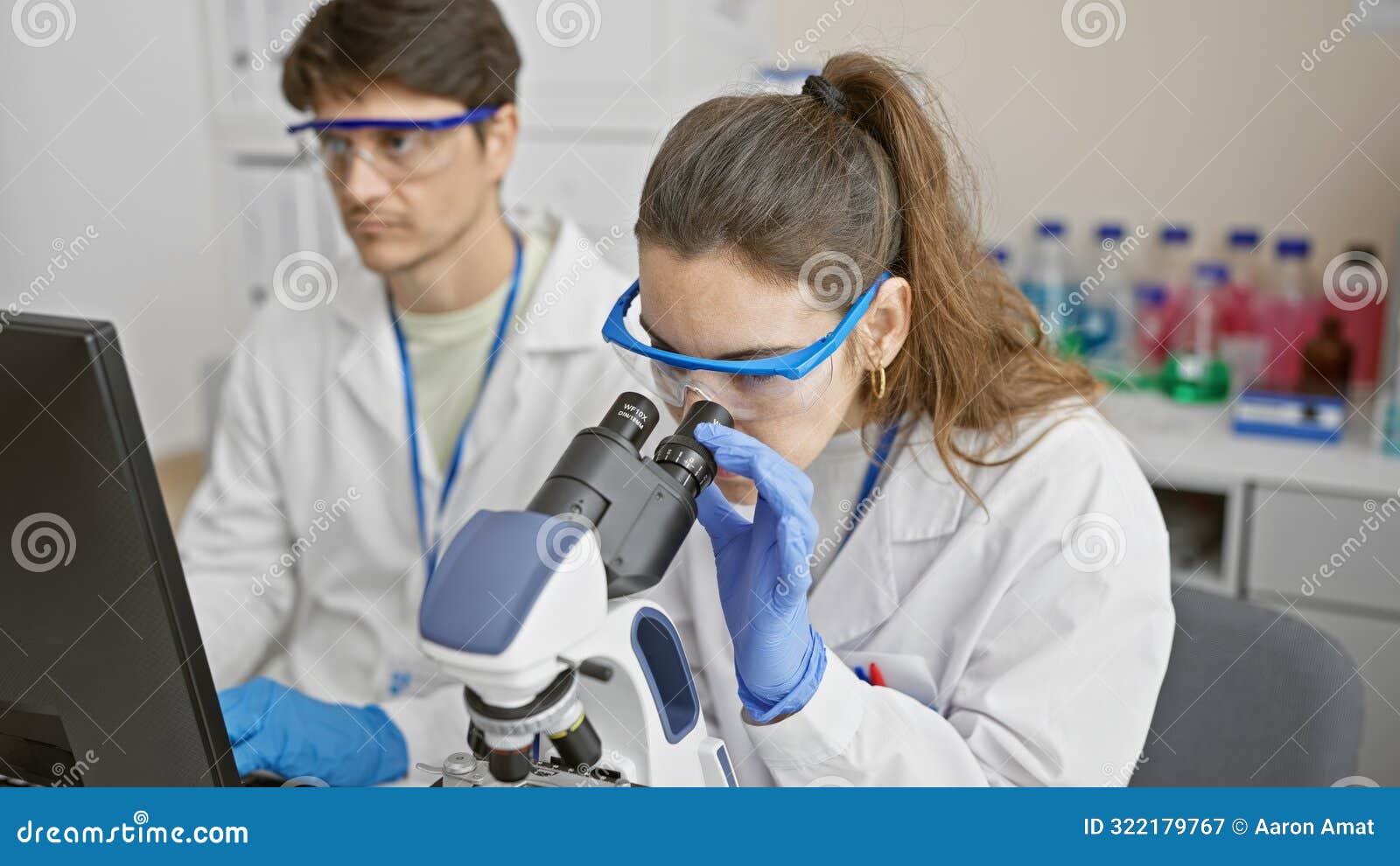 A Woman and Man Scientists Working Together in a Laboratory, with ...