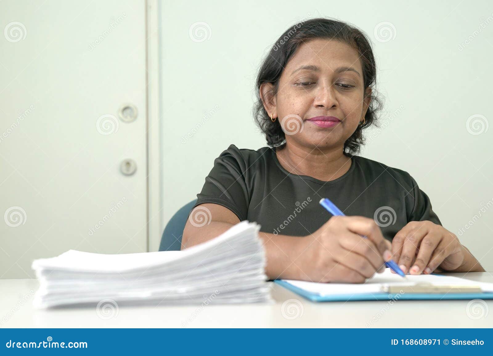 Woman Manager or Executive Going through a File and Writing with a Pen ...