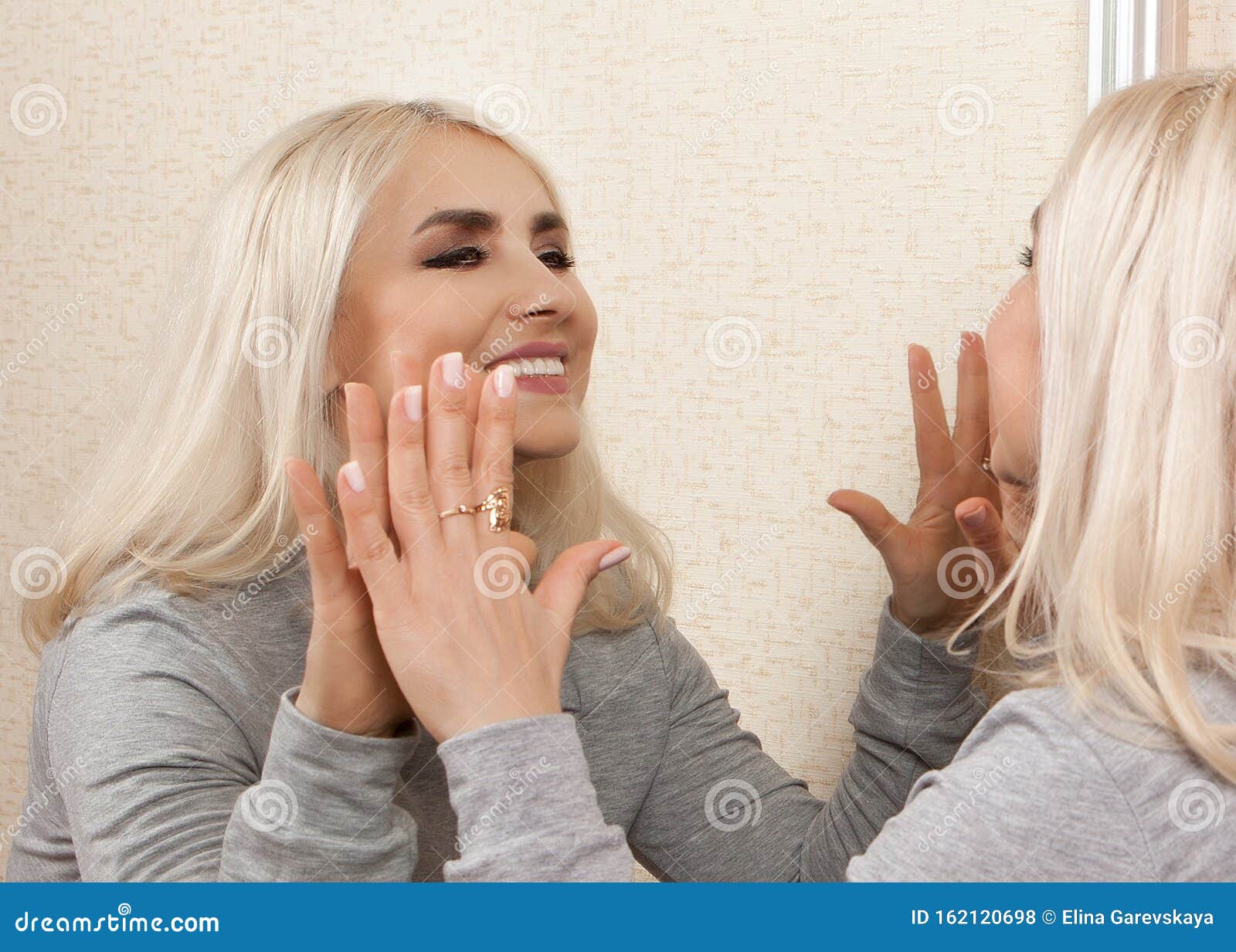 The Woman at the Mirror Touches Her Reflection with Her Hands Stock ...