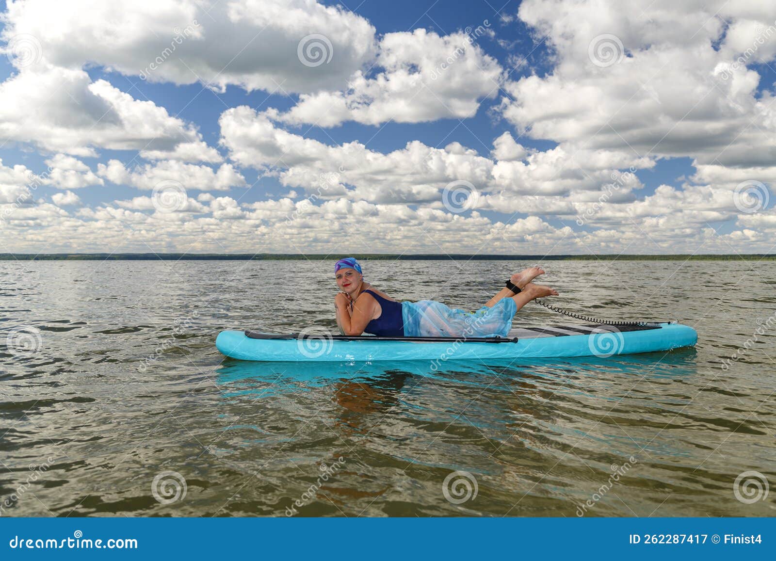 A Woman With A Mohawk In A Pareo Lies Sunbathing On A Sup Board In A