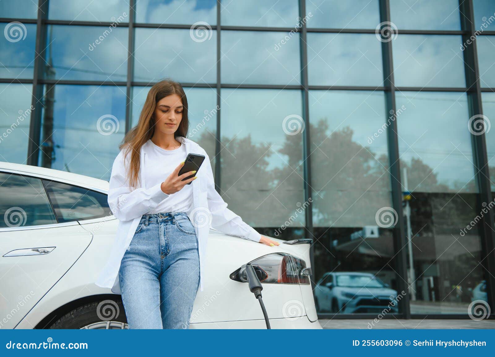 Woman Near Electric Car Vehicle Charged At The Charging Station Stock