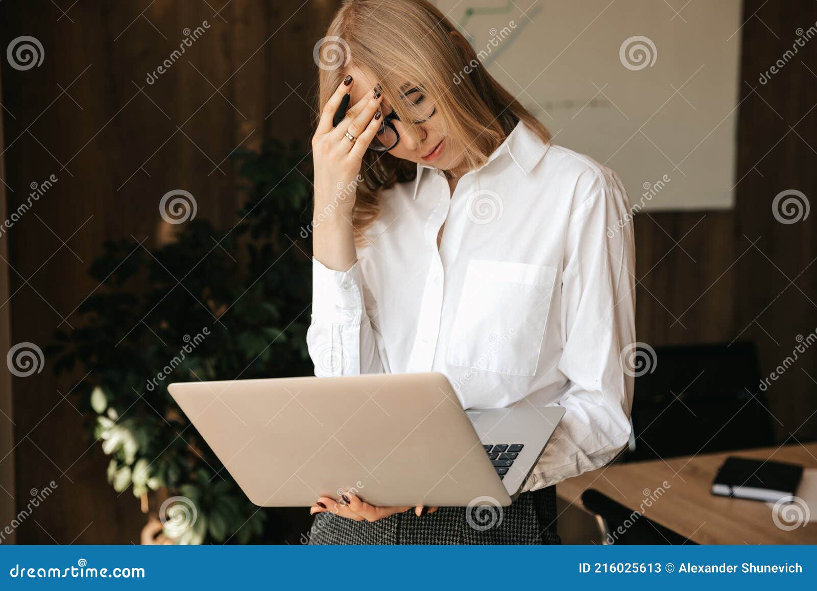 Woman Office Worker Performs Difficult Tasks on a Laptop, Working on ...
