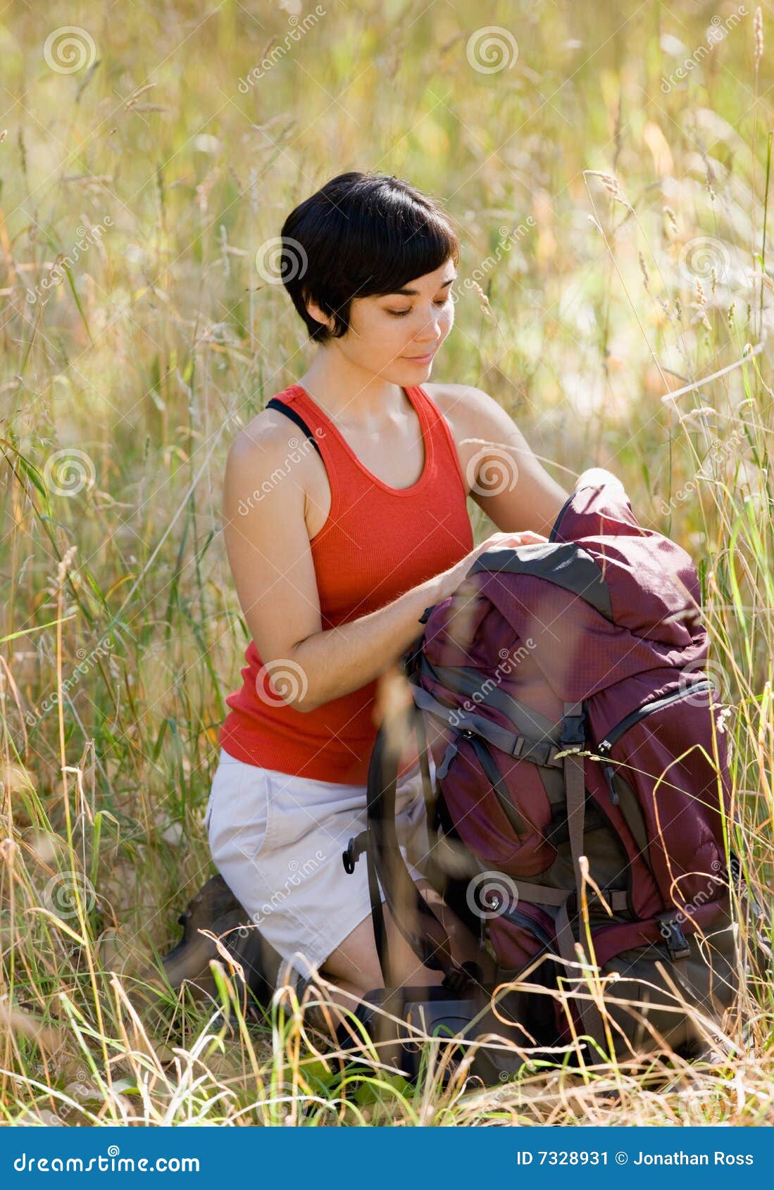 Woman opening backpack stock image. Image of kneel, field - 7328931