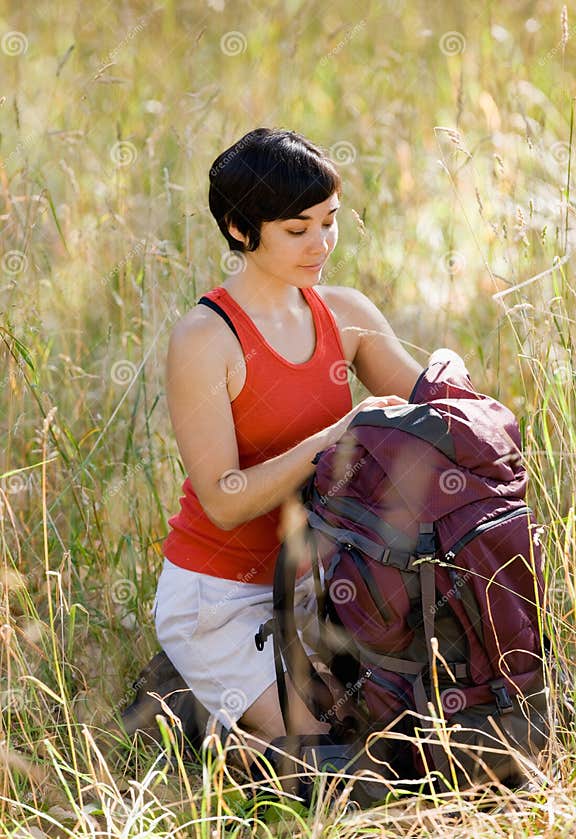 Woman opening backpack stock image. Image of kneel, field - 7328931