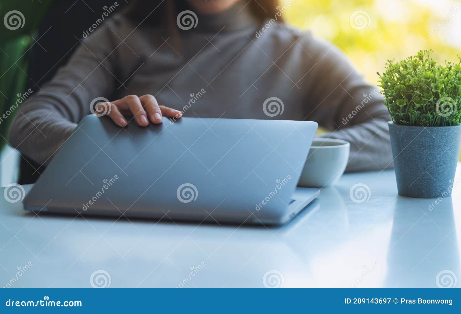 A Woman Opening a Laptop Computer Getting Ready for Work in Office ...