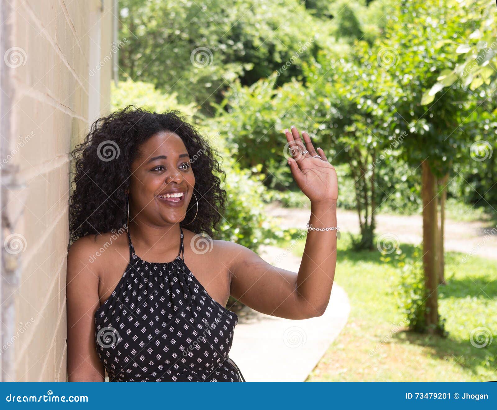 Woman Outside Leaning on a Wall Waving at Someone Stock Image - Image ...