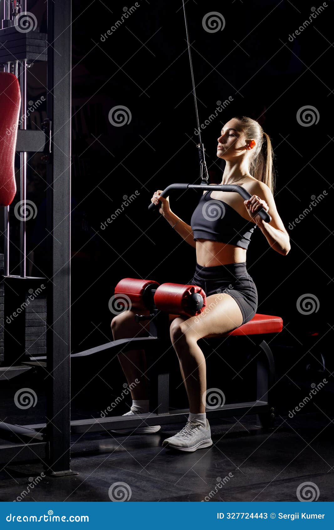 Woman Performing Lat Pulldown Exercise on a Cable Machine in a Gym ...