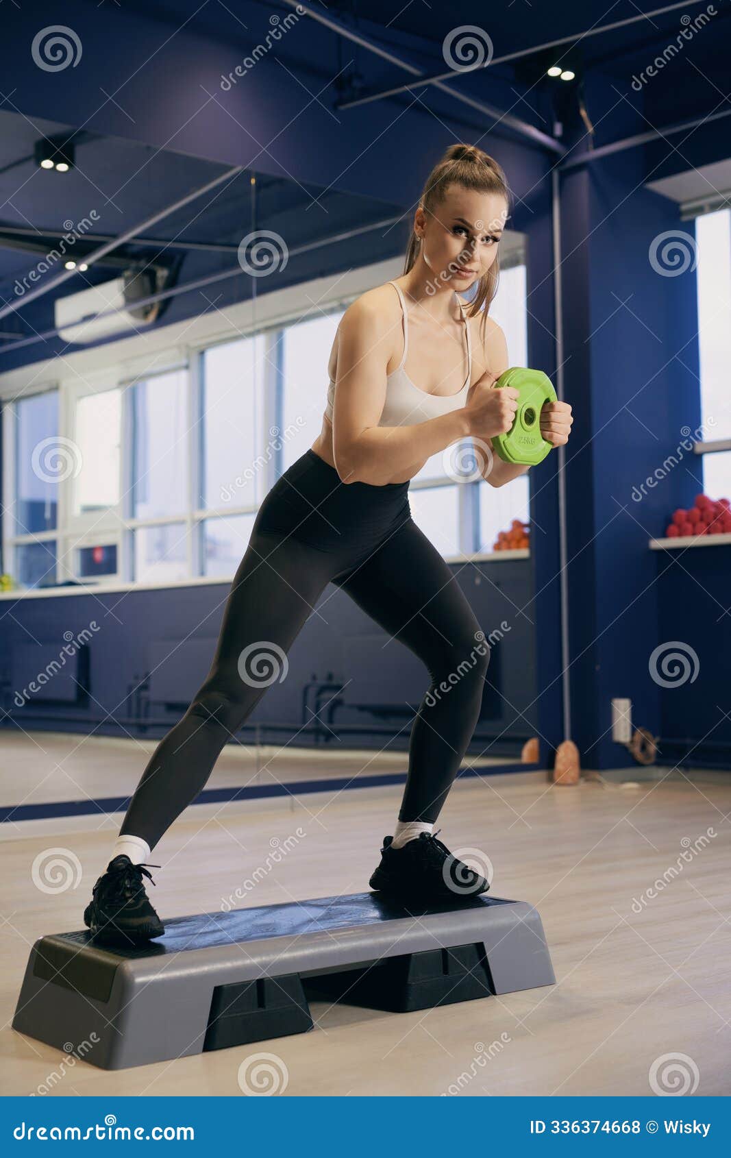 Woman Performing a Step Workout Using Dumbbells in a Gym Studio Stock ...