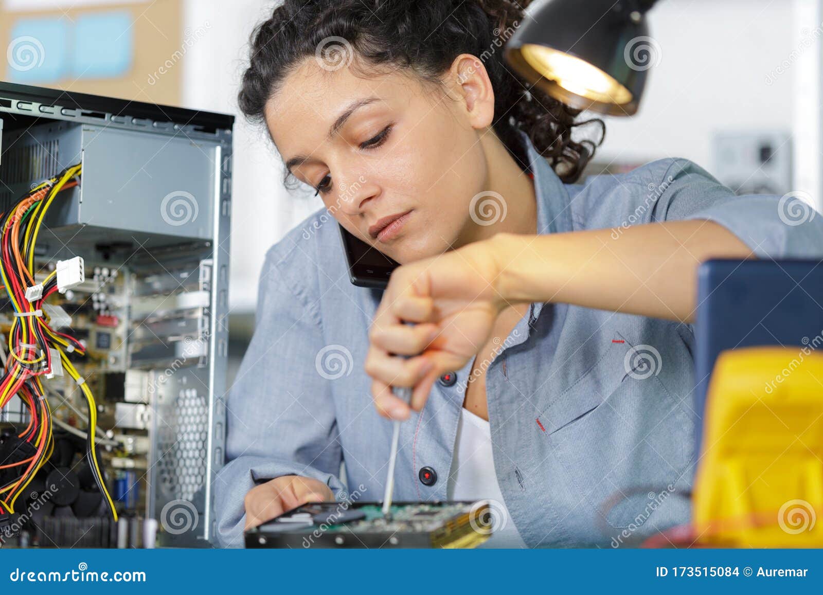 Woman on Phone with Screwdriver Setting Up Computer Stock Photo - Image ...