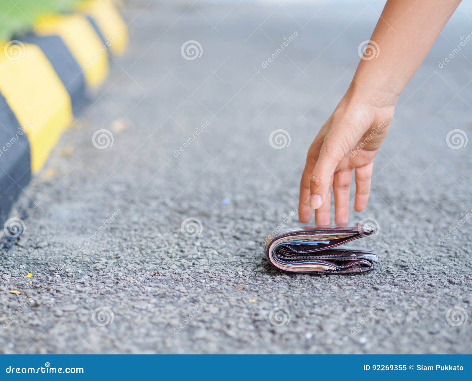A Woman Picking Up Fallen Wallet on Road Side. Stock Image - Image of ...