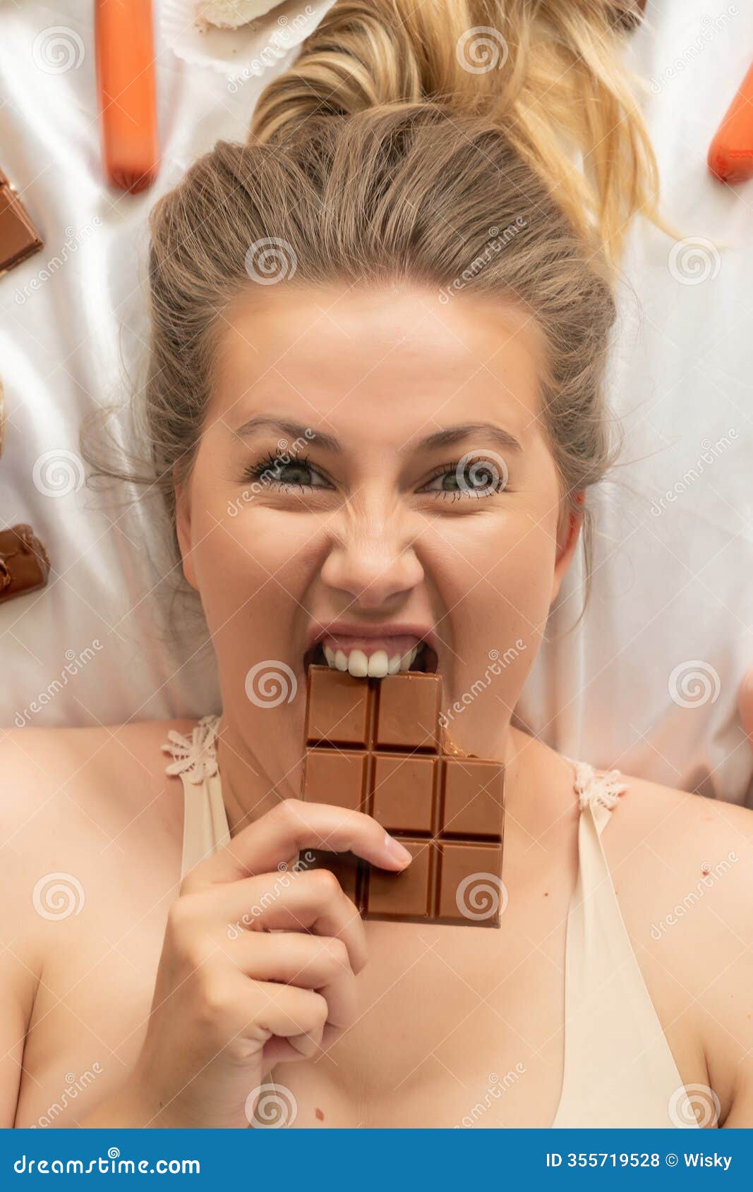 Woman Enjoying Chocolate while Lying on a Bed Surrounded by Sweets ...