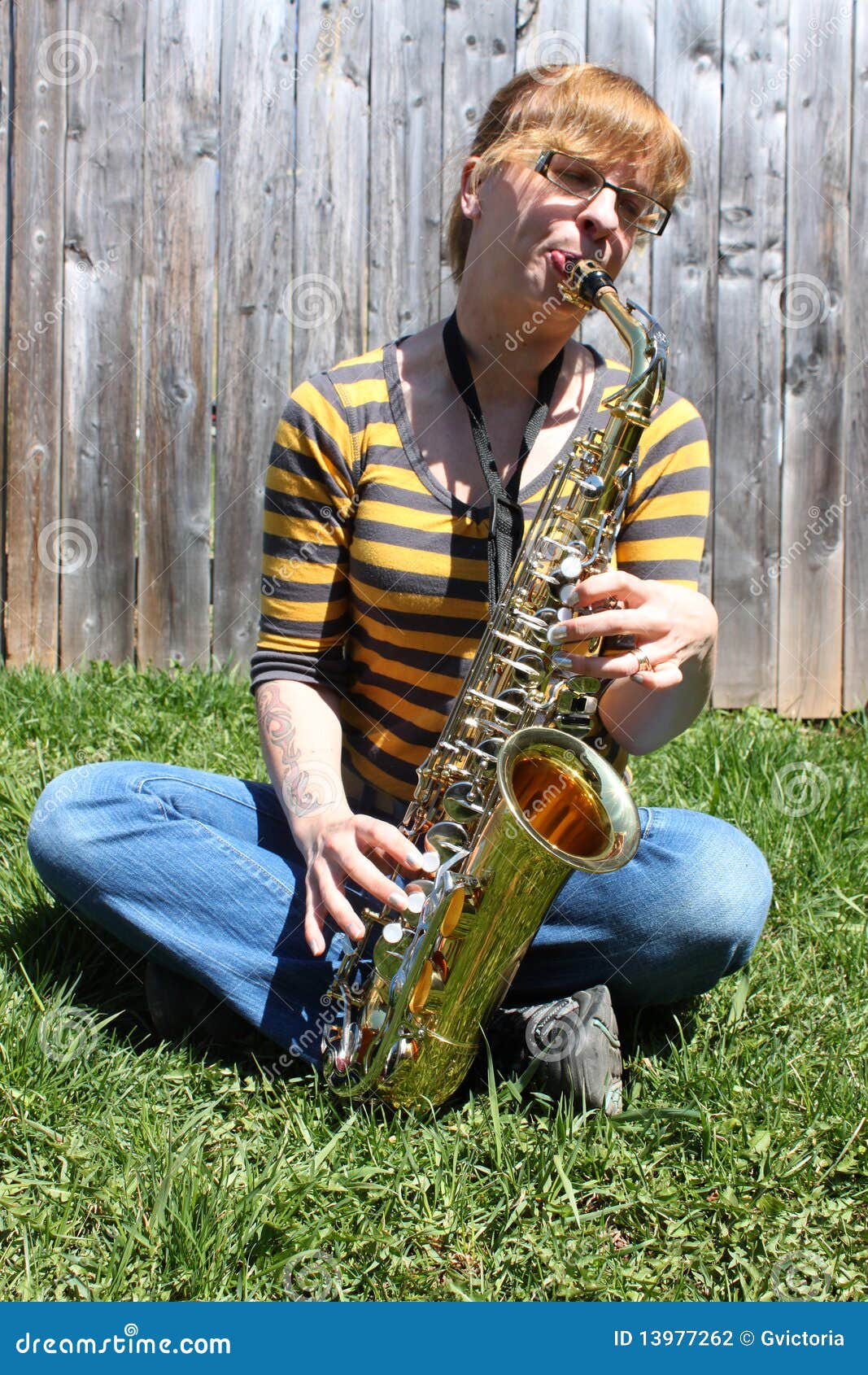 Woman Plays Saxaphone Outdoors Stock Photo - Image of jeans, outside ...