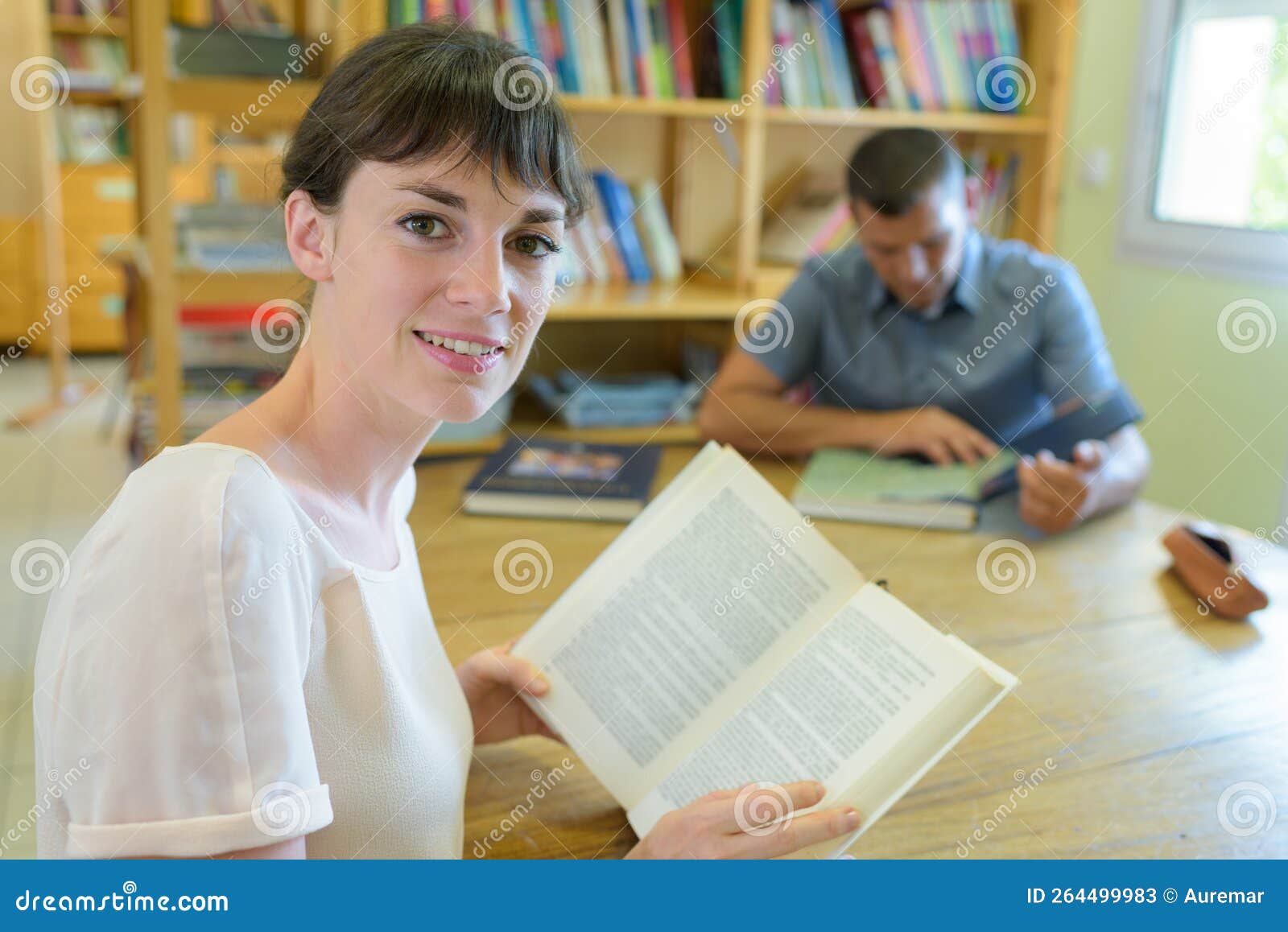 Woman Posing Holding Book in Library Stock Image - Image of university ...