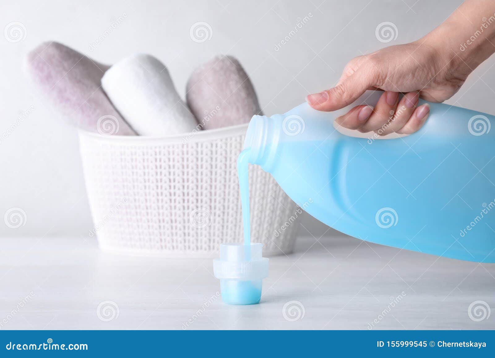 Woman Pouring Laundry Detergent into Cap on Against Light Background ...