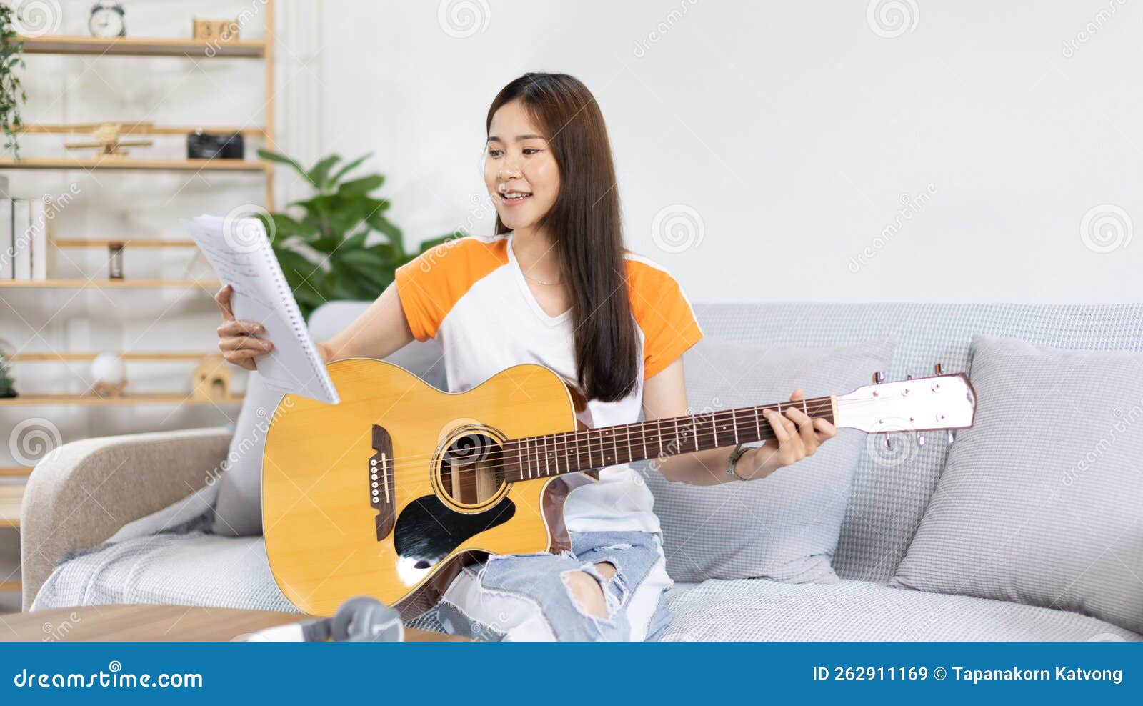 Woman Practicing or Learning To Play Guitar and Practice Using His ...