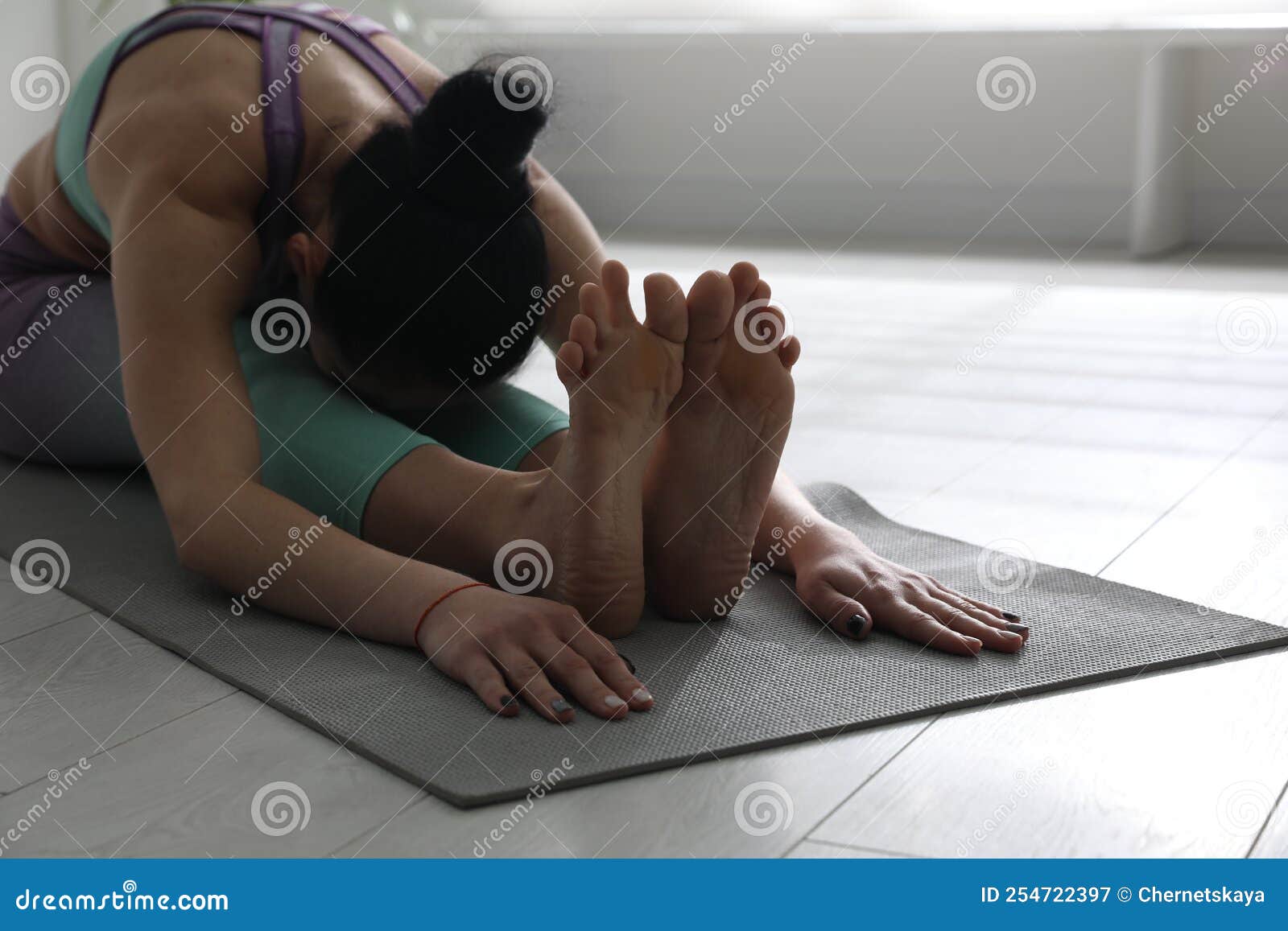 Woman Practicing Seated Forward Bend Asana in Studio. Paschimottanasana ...