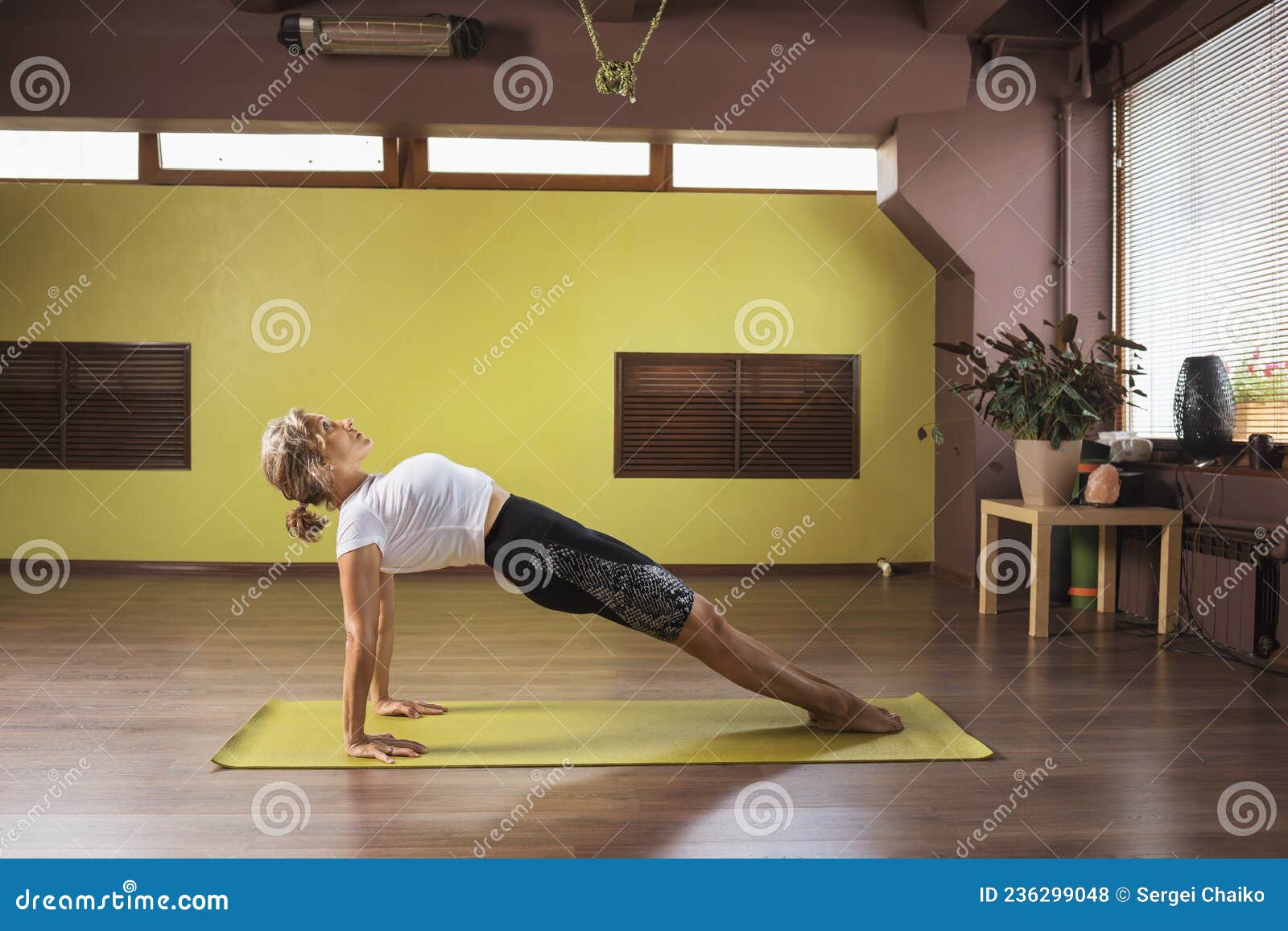A Woman Practicing Yoga, Performs the Purvottanasana Exercise, Stands ...