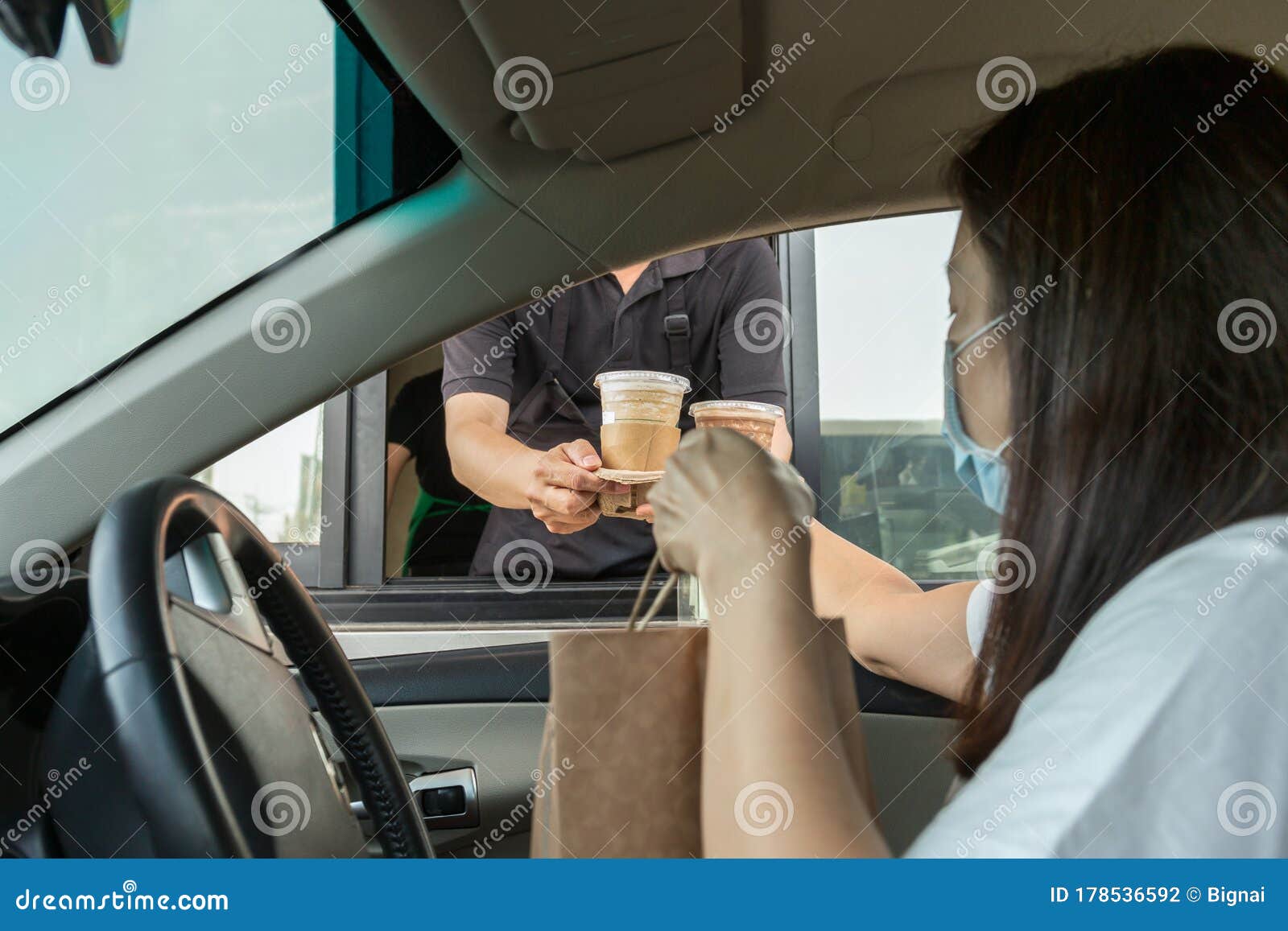 Woman in Protective Mask Taking Coffee at Drive Thru during Covid-19 ... Woman in Protective Mask Taking Coffee at Drive Thru during Covid-19 ...