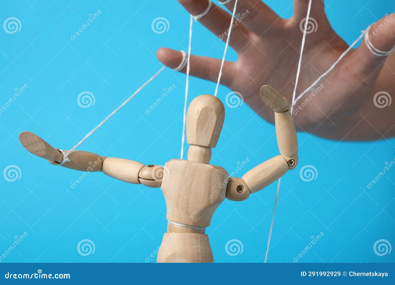 Woman Pulling Strings of Puppet on Light Blue Background, Closeup Stock ...