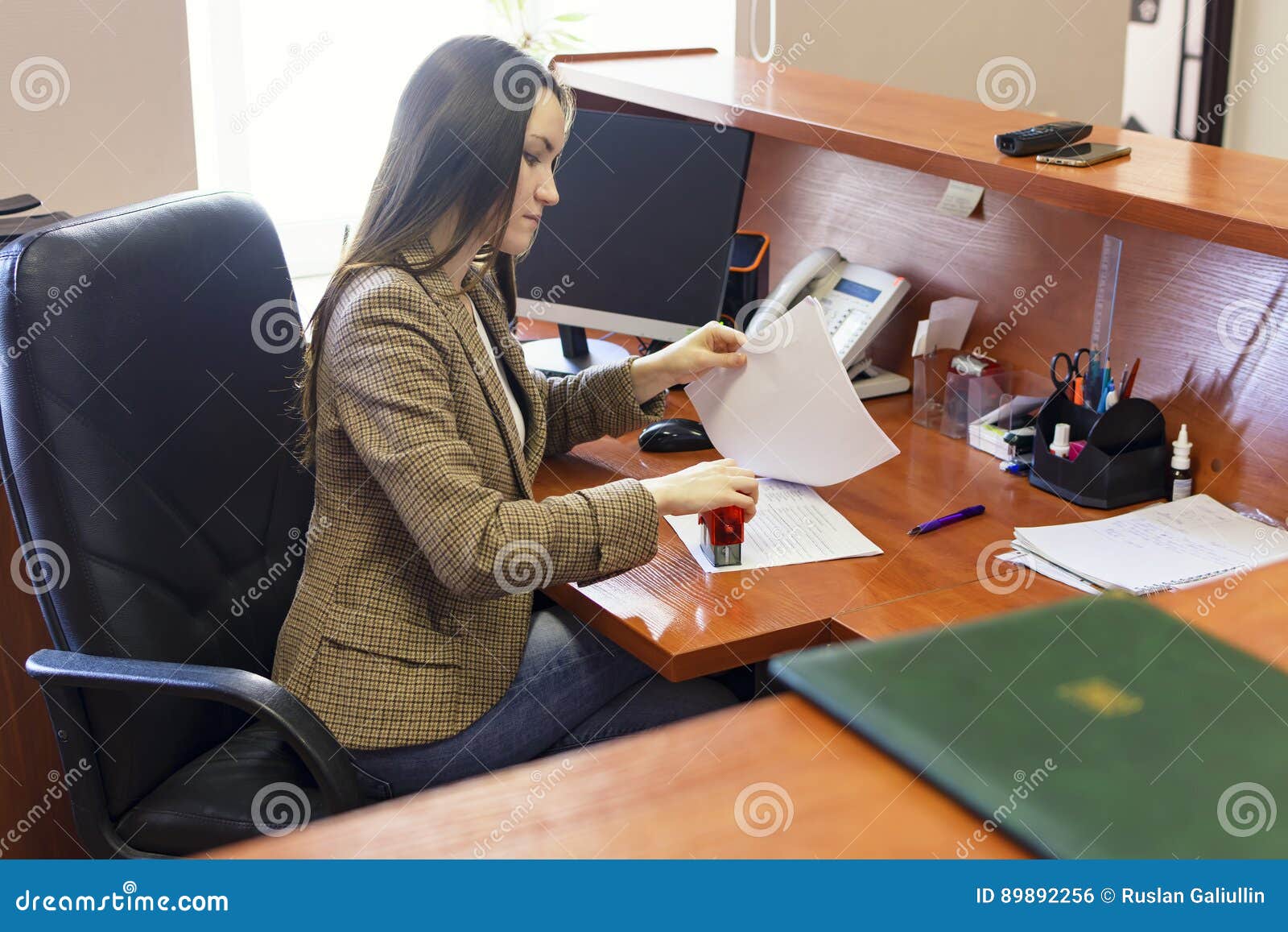 The Woman Puts a Stamp To the Document on the Desktop. the Work in the ...
