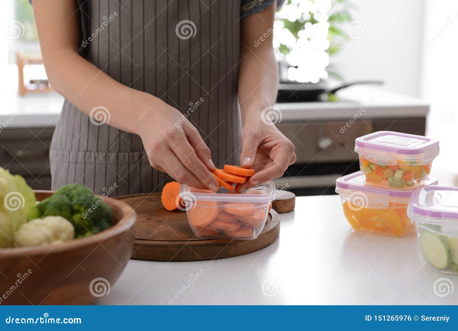 Woman Putting Fresh Carrot Slices into Plastic Container for Freezing ...