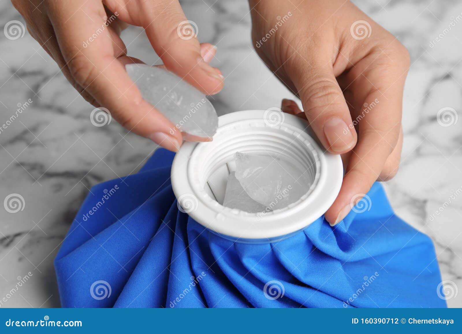 Woman Putting Ice Cubes into Pack at Marble Table Stock Photo - Image ...