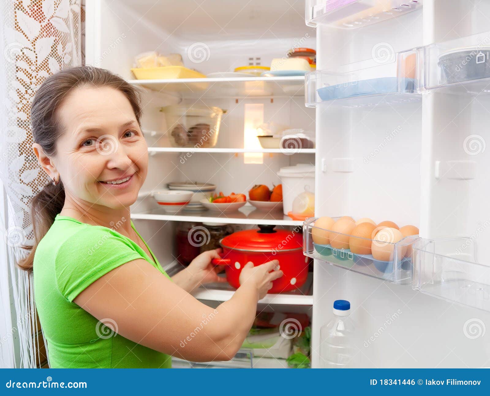 Woman Putting Pan into Fridge Stock Photo - Image of lifestyle, eating ...