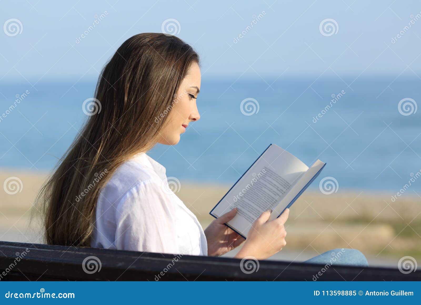 Woman Reading a Book on a Bench on the Beach Stock Image - Image of ...