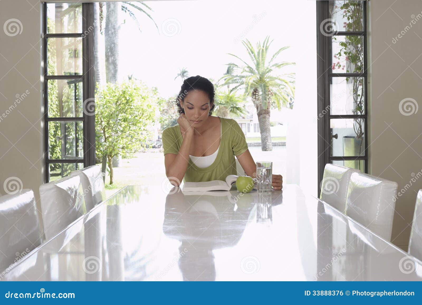 Woman Reading Book at Dining Table Stock Photo - Image of black ...