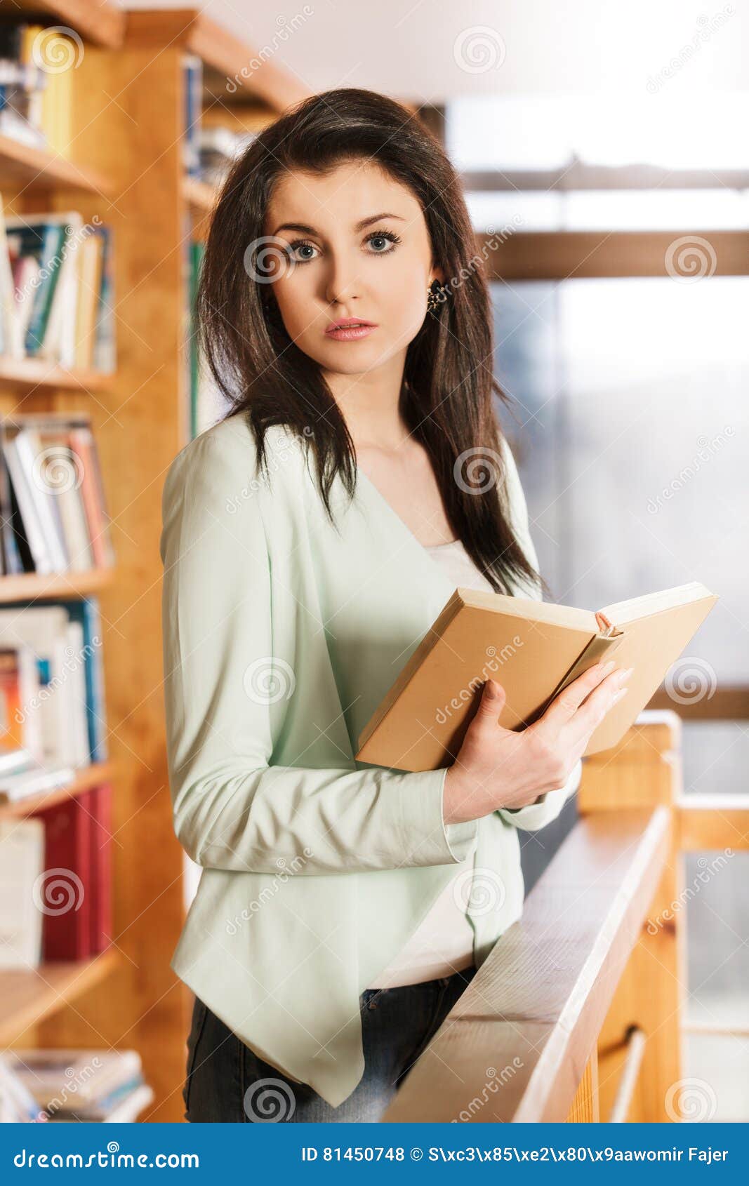 Woman Reading a Book in Front of Bookshelves Stock Photo - Image of ...