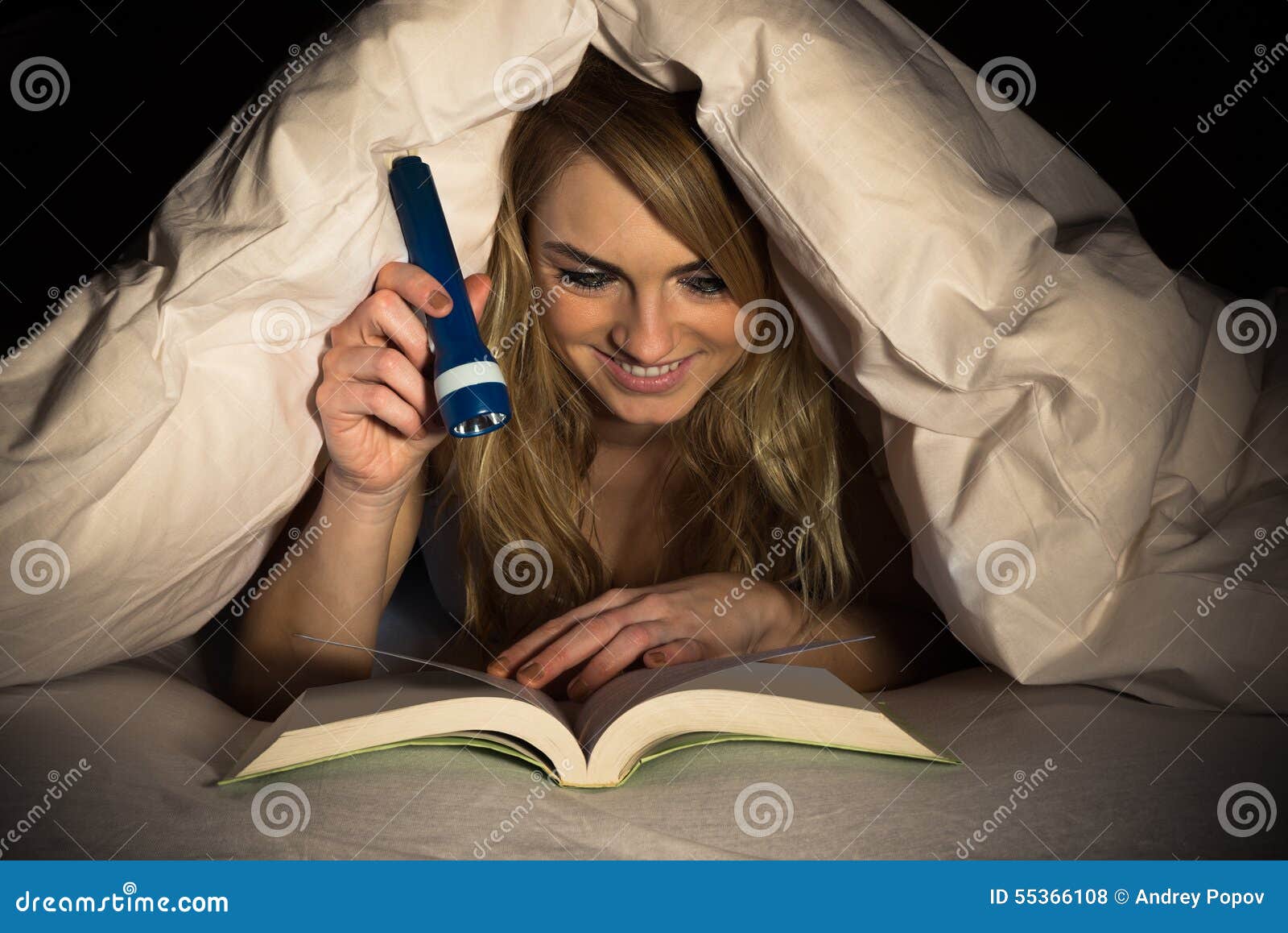 Woman Reading Book Holding Torch Stock Photo - Image of bedding, page ...