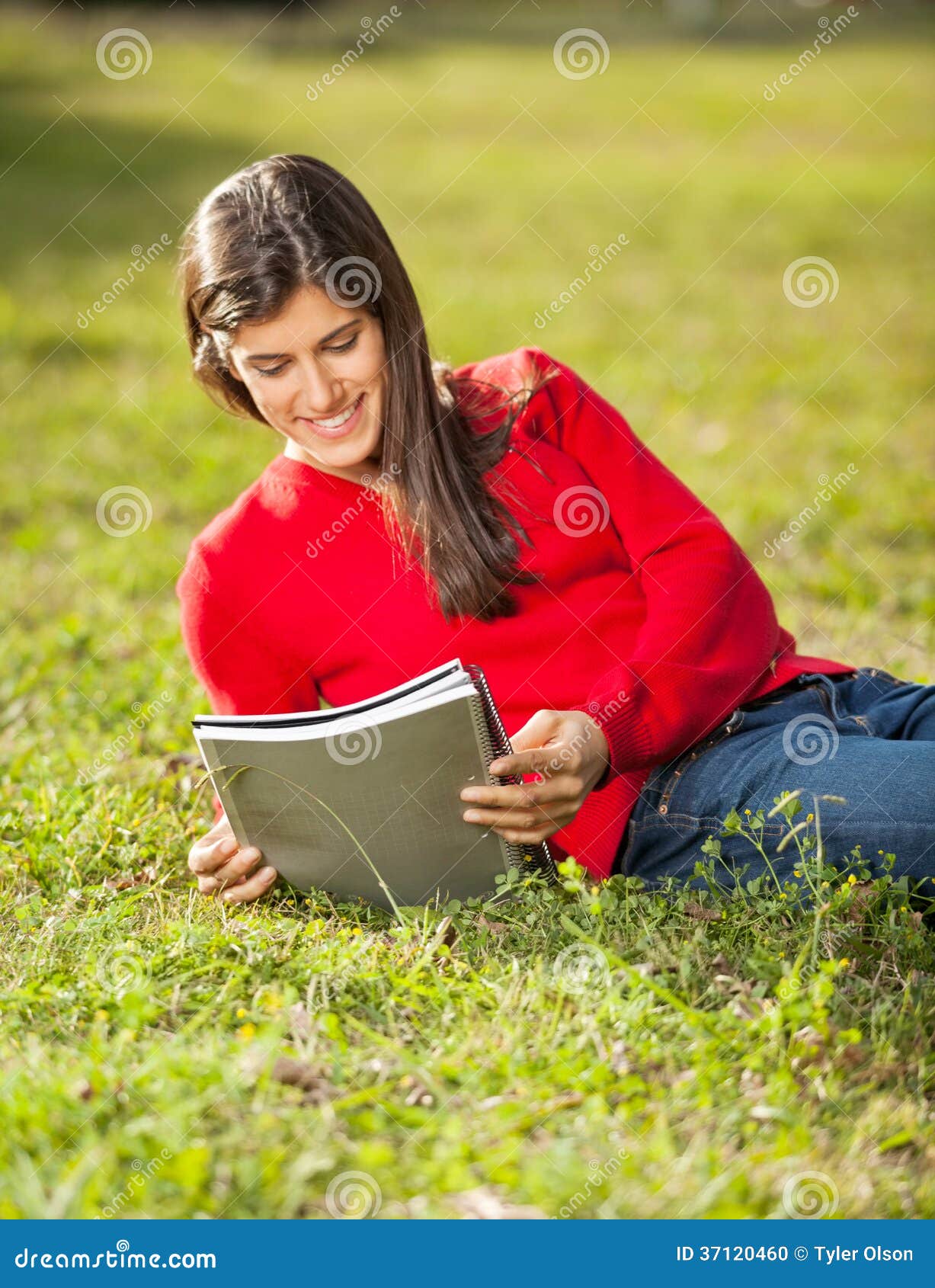 Woman Reading Book while Relaxing on Grass at Stock Photo - Image of ...