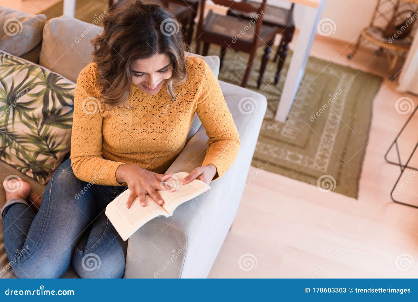 Woman reading book on sofa stock image. Image of lying - 170603303