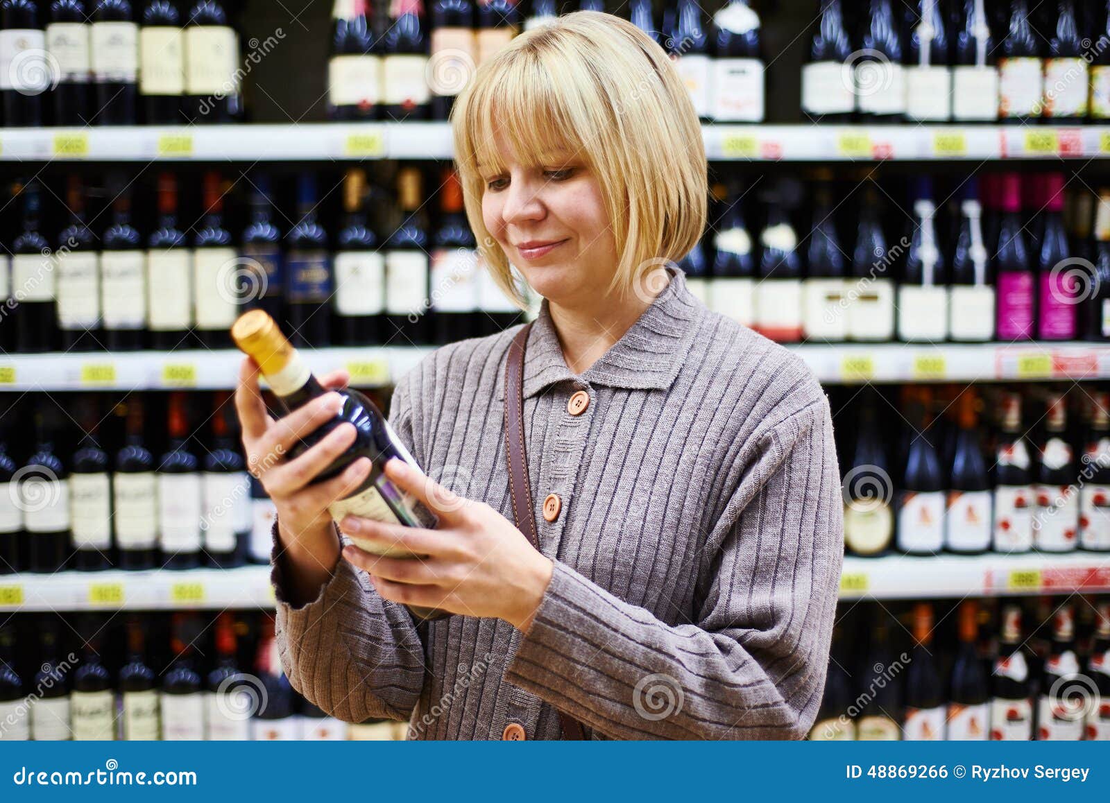 Woman Reading Label on Bottle of Wine in Store Stock Photo - Image of ...
