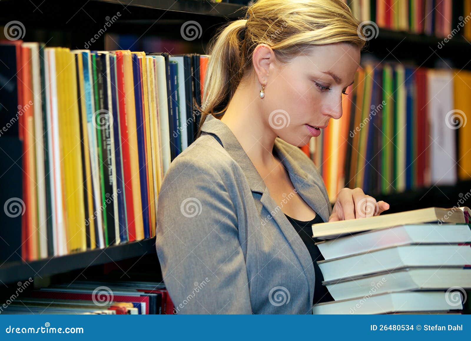 Woman reading in a library stock photo. Image of library - 26480534