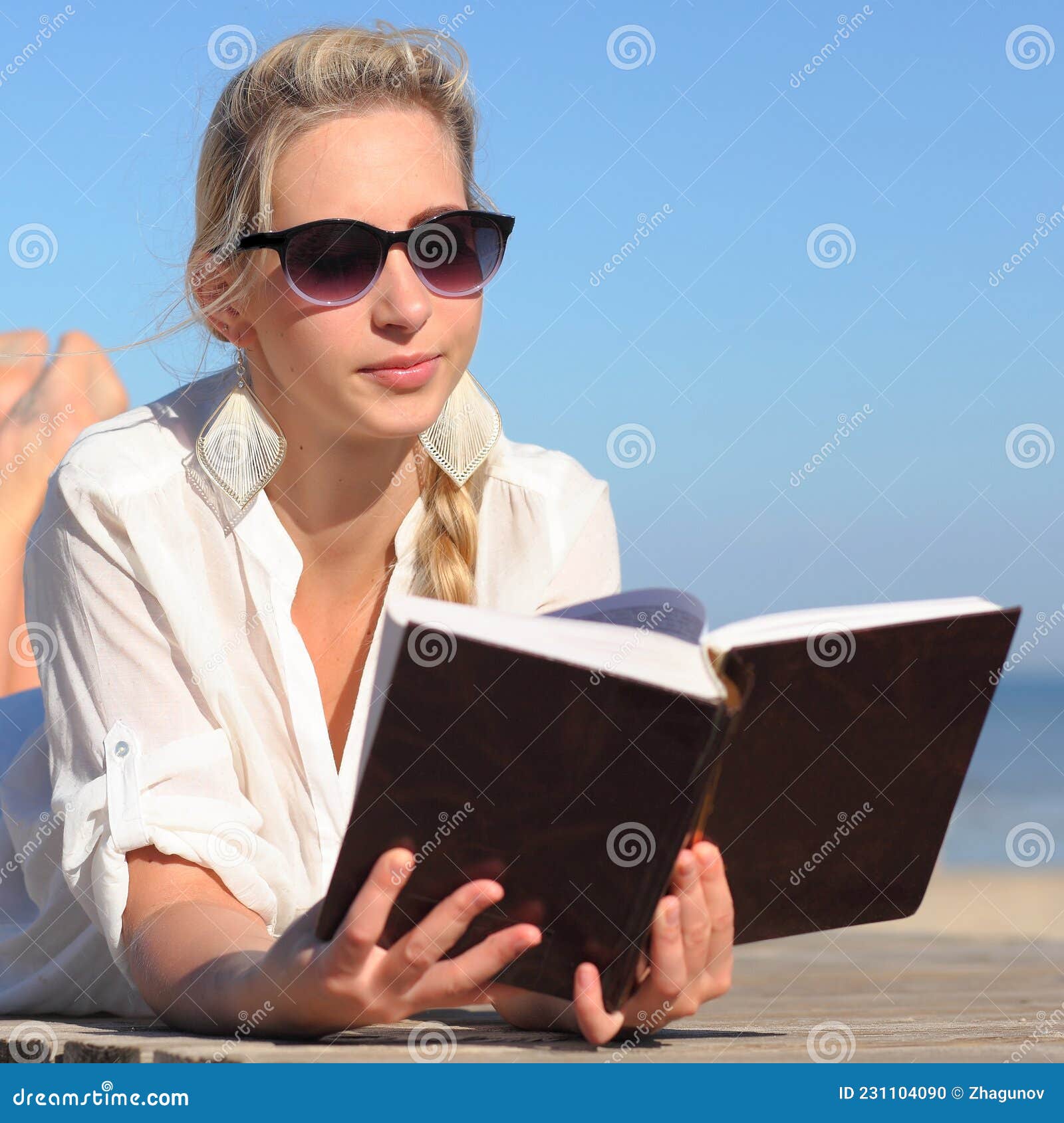Woman Reads a Book on the Beach Stock Photo - Image of lawn, lying ...