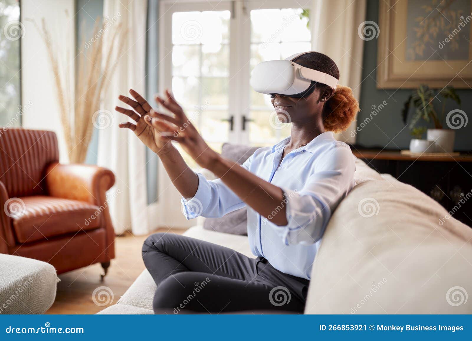 Woman Relaxing on Sofa at Home Wearing VR Headset and Interacting with ...