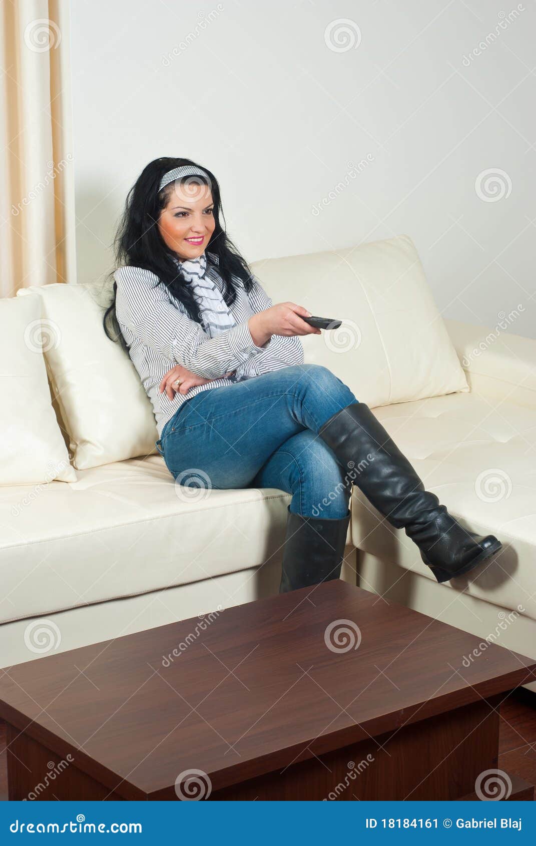 Woman with remote on couch stock image. Image of indoor - 18184161