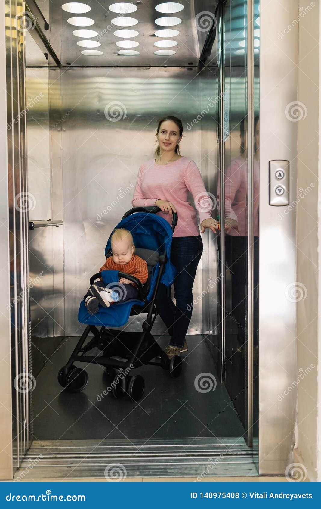 Woman Rides in an Elevator with a Baby in a Stroller in a Mall. Stock ...