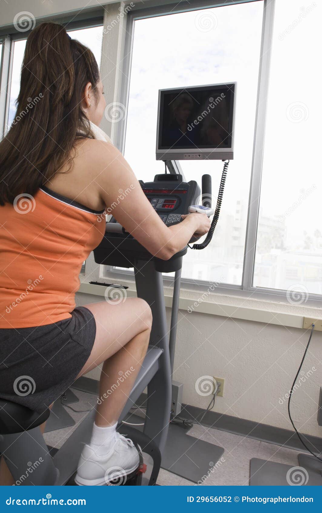 Woman Riding an Exercise Bike Stock Photo - Image of full, rear: 29656052
