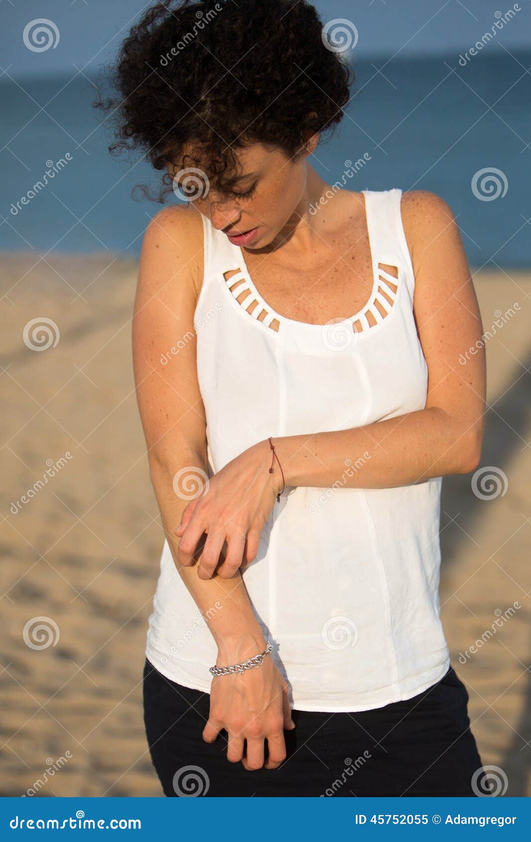 Woman rubs arm stock image. Image of sonnenalergie, bruenett - 45752055