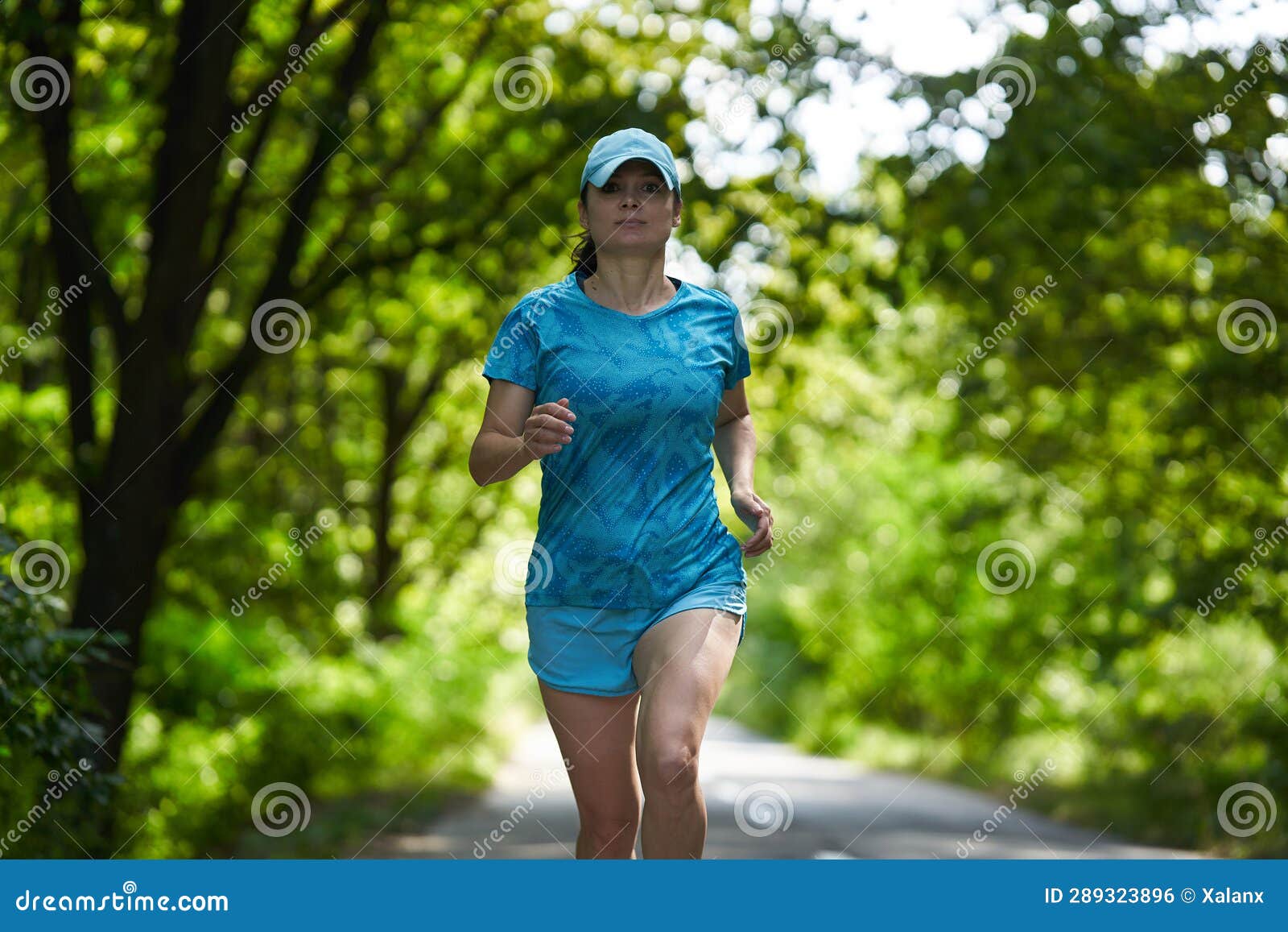 Woman Running through Forest on Asphalt Stock Photo - Image of happy, dirt: 289323896