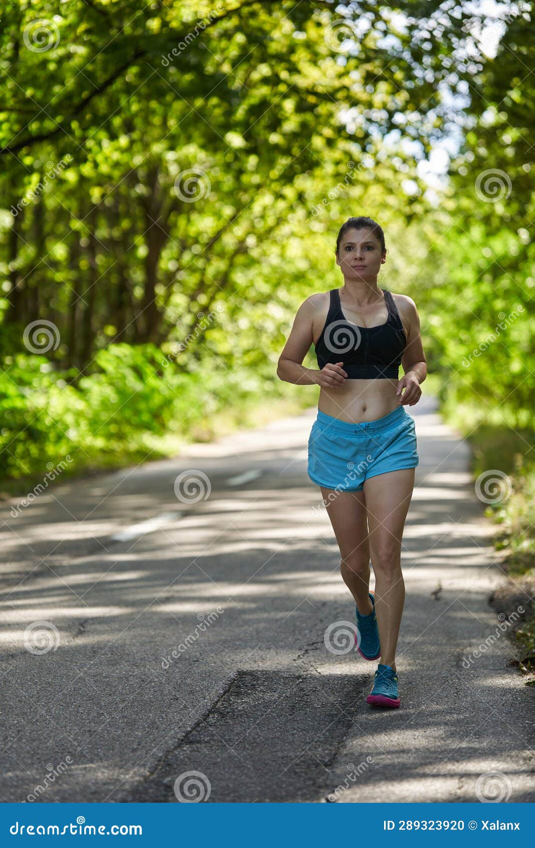 Woman Running through Forest on Asphalt Stock Photo - Image of lifestyle, trainer: 289323920
