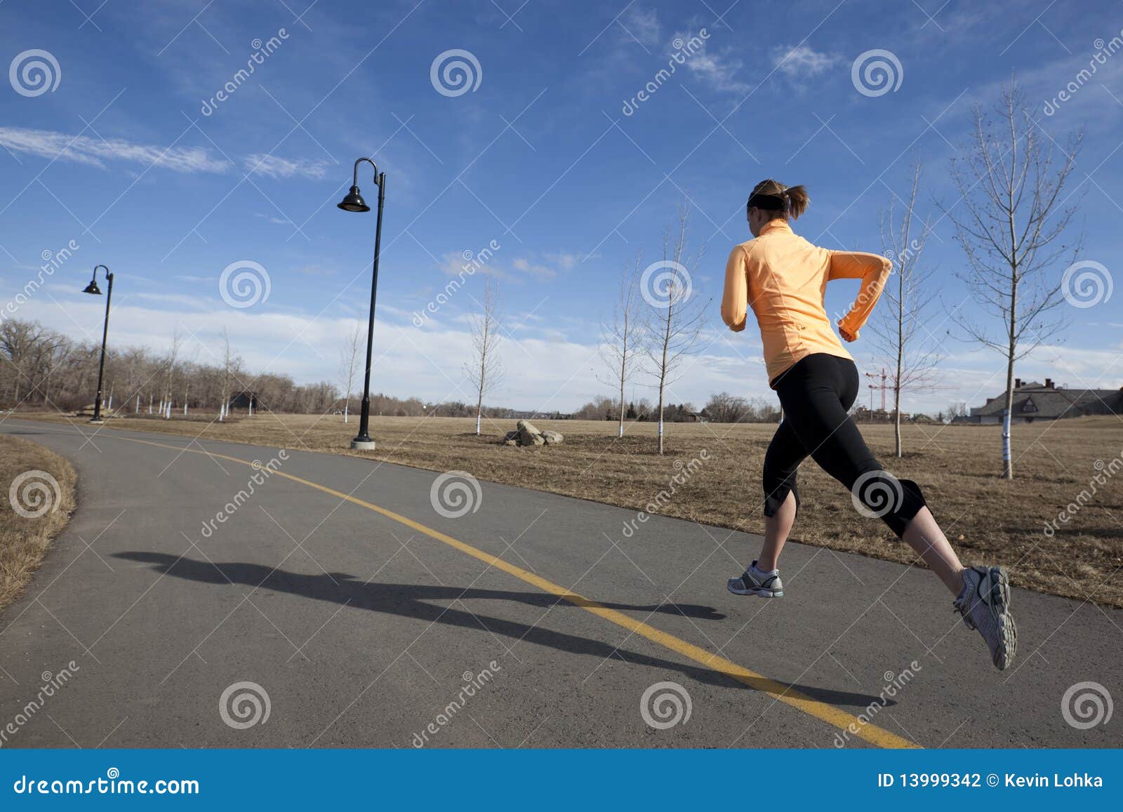 Woman running on city path stock photo. Image of orange - 13999342