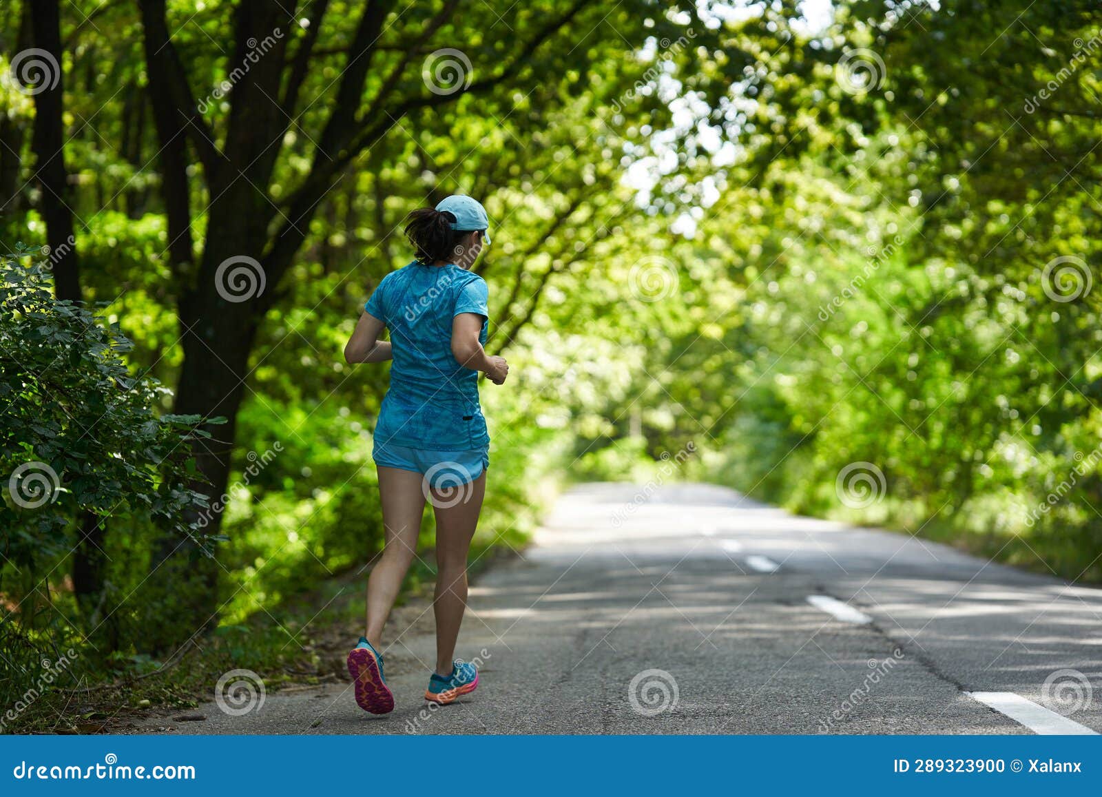 Woman Running through Forest on Asphalt Stock Photo - Image of female ...