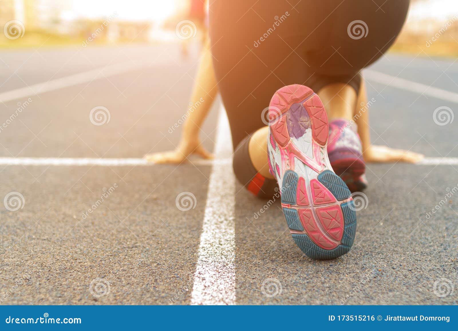 Woman in Running Start Pose on the Blue Running Track in Stadium Stock ...