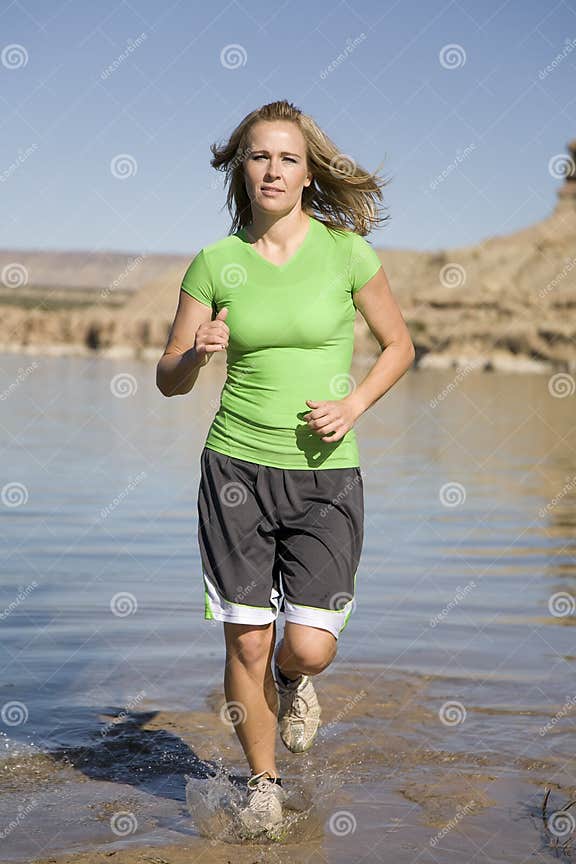 Woman runs in water stock photo. Image of shorts, water - 11107938