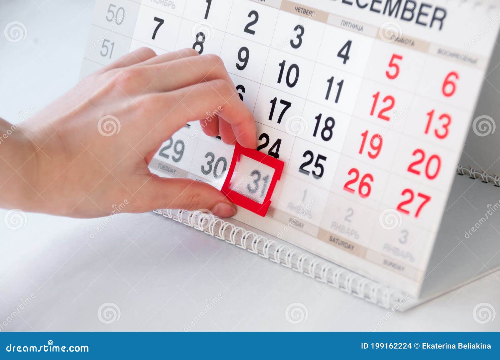 A Woman`s Hand Moves the Pointer on a Calendar on a White Background ...