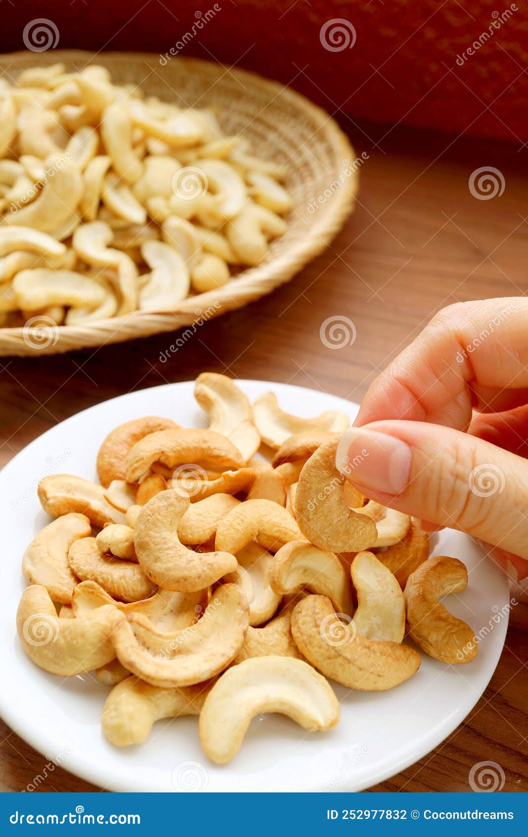 Woman`s Hand Picking a Roasted Cashew Nut Kernel from Snack Saucer ...
